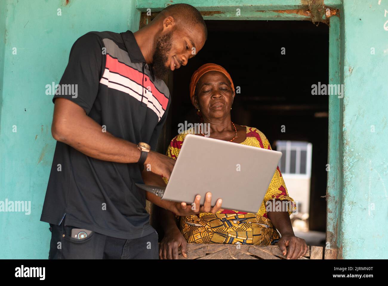african man explaining to an elderly african woman with laptop Stock ...