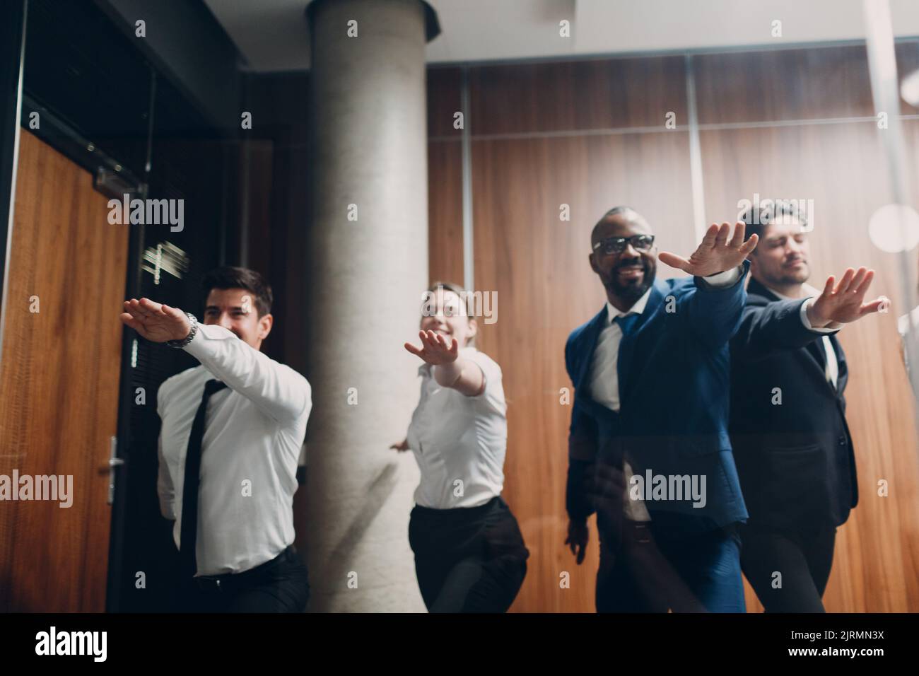 Businessman and businesswoman team doing warming up and yoga exercises ...