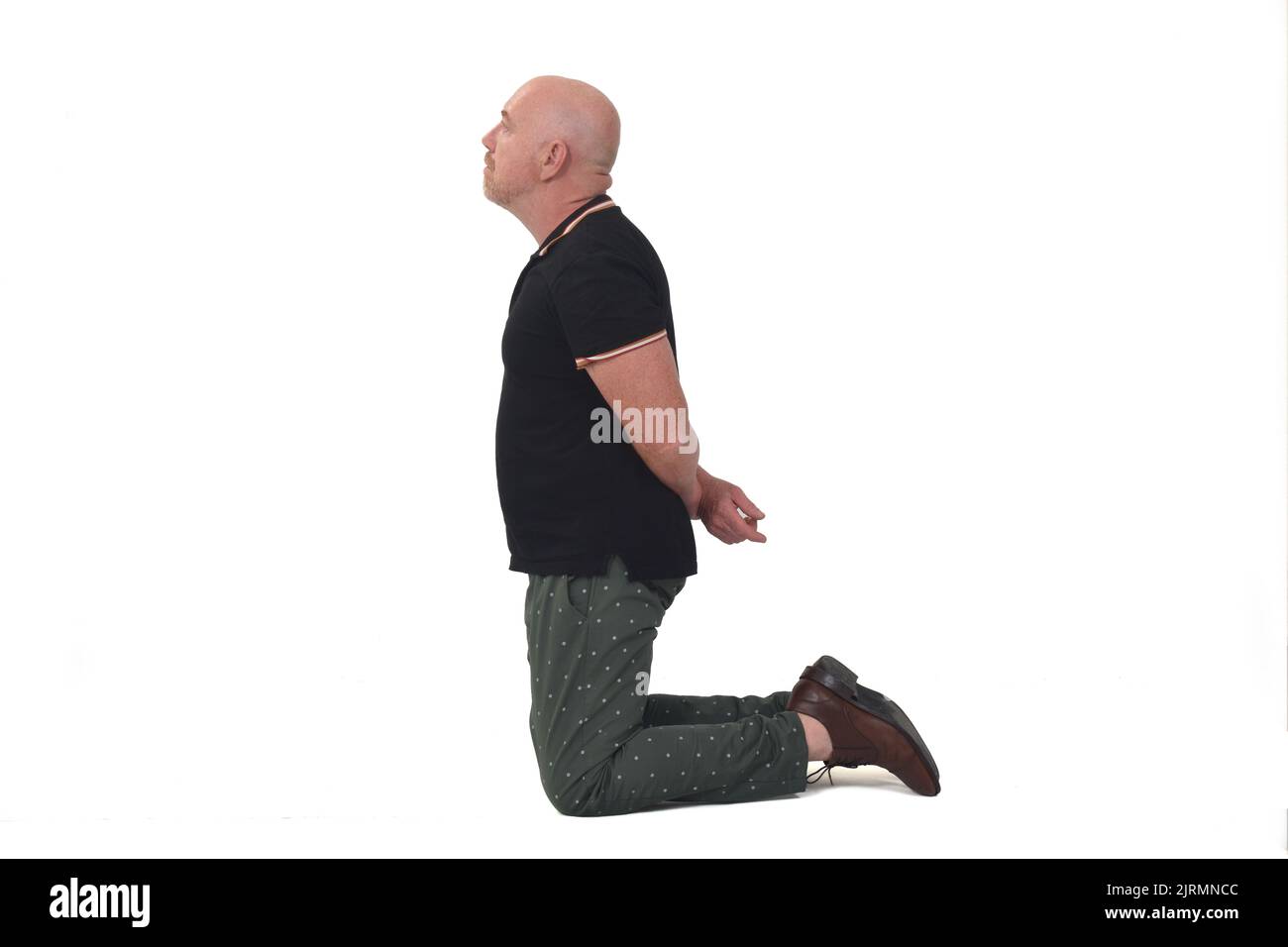 man on kness looking away on white background Stock Photo - Alamy