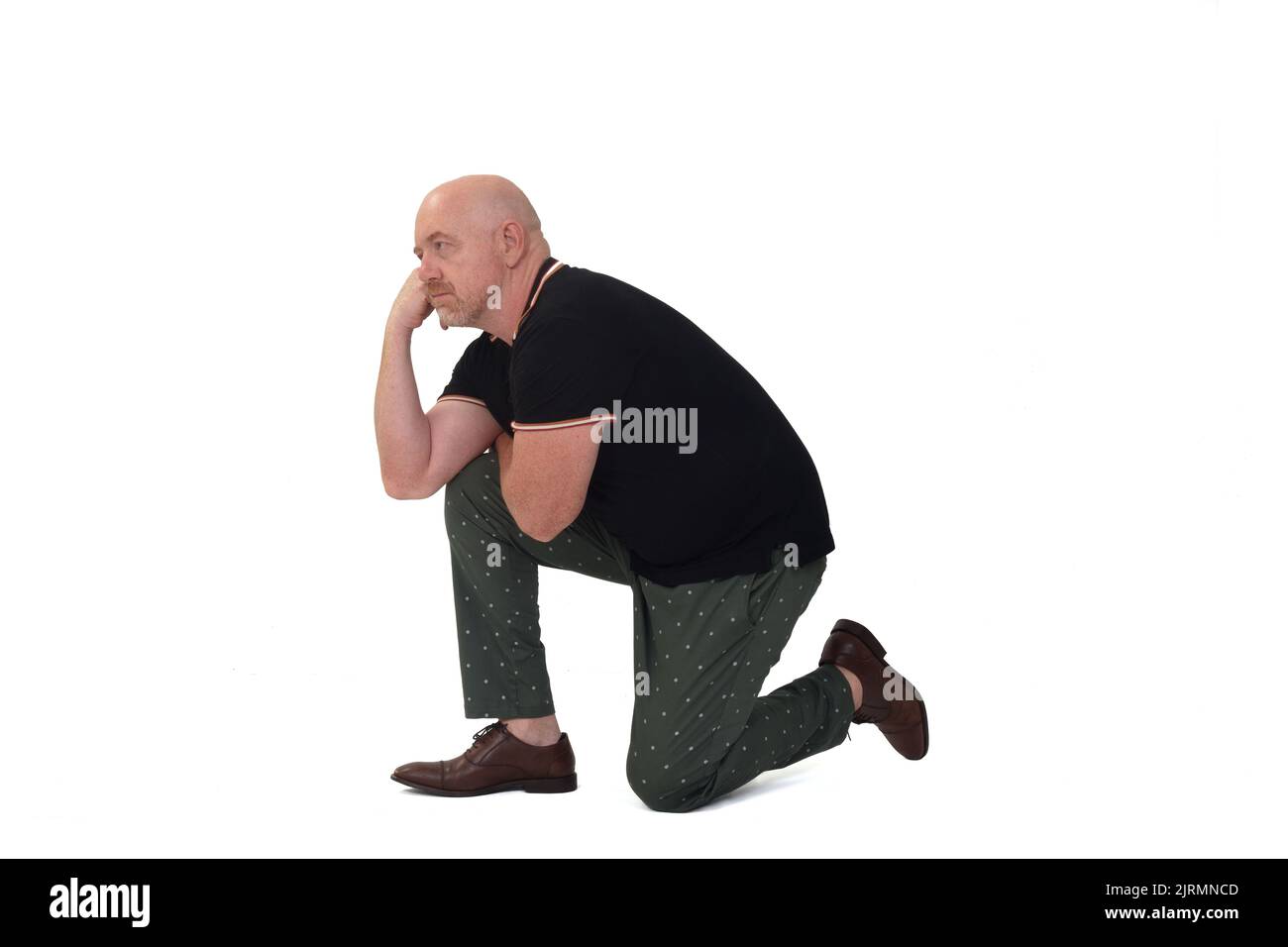 profile view of a man sitting with his knee on the ground thinking ...