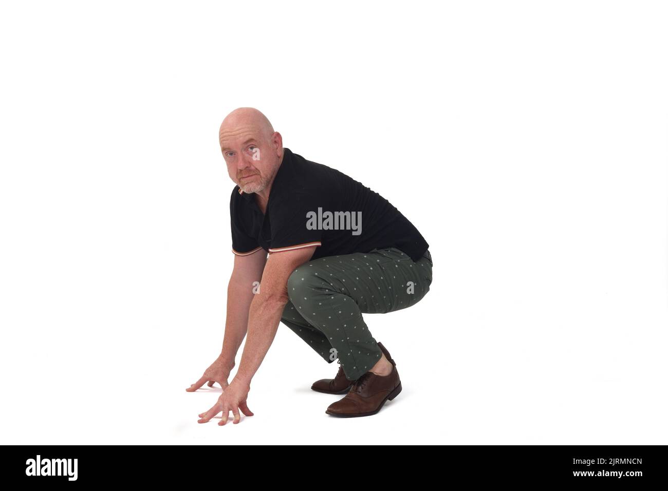 man looking at camera and sitting squatting on white background Stock ...