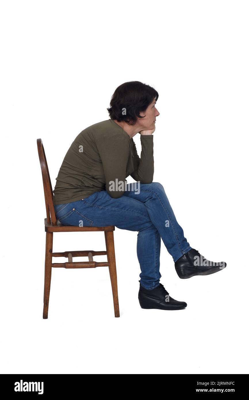 side view of woman sitting on a chair with hand on chin on white ...
