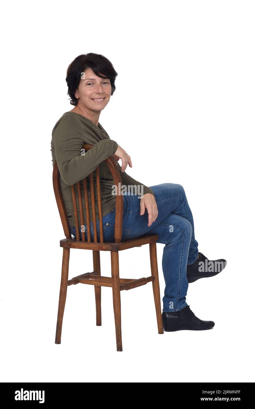 happy woman sitting on a chair turning and looking at the camera on ...