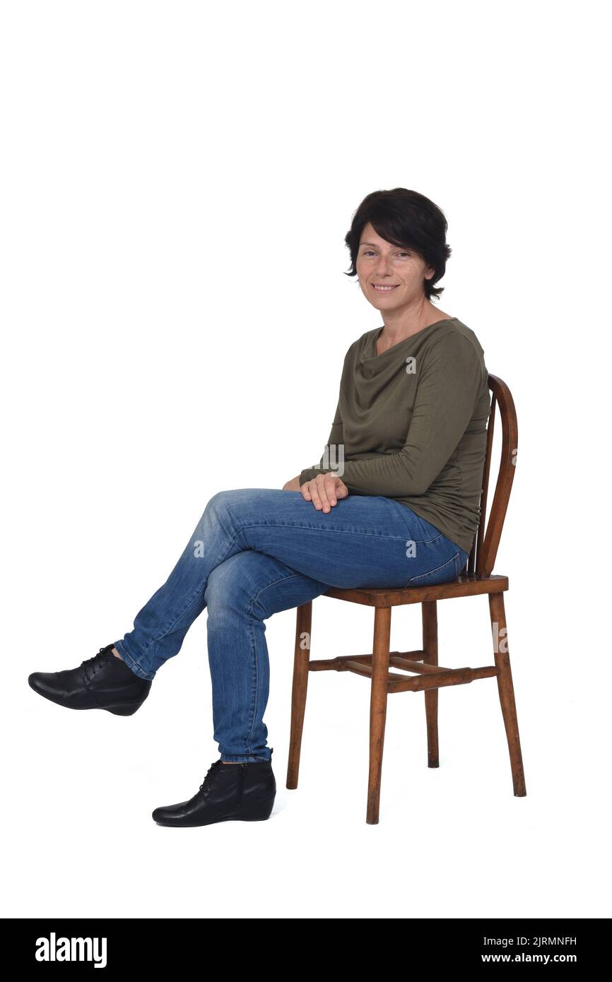 side view woman sitting on a chair looking at the camera and legs ...