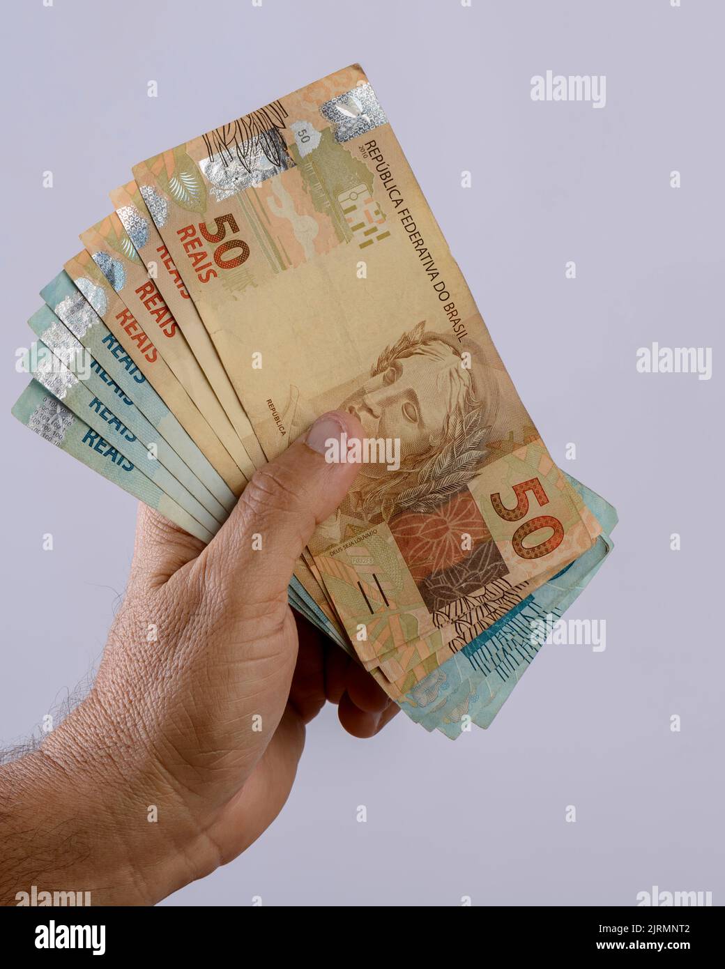 Hand holding money, six hundred reais, Brazilian currency, on white ...