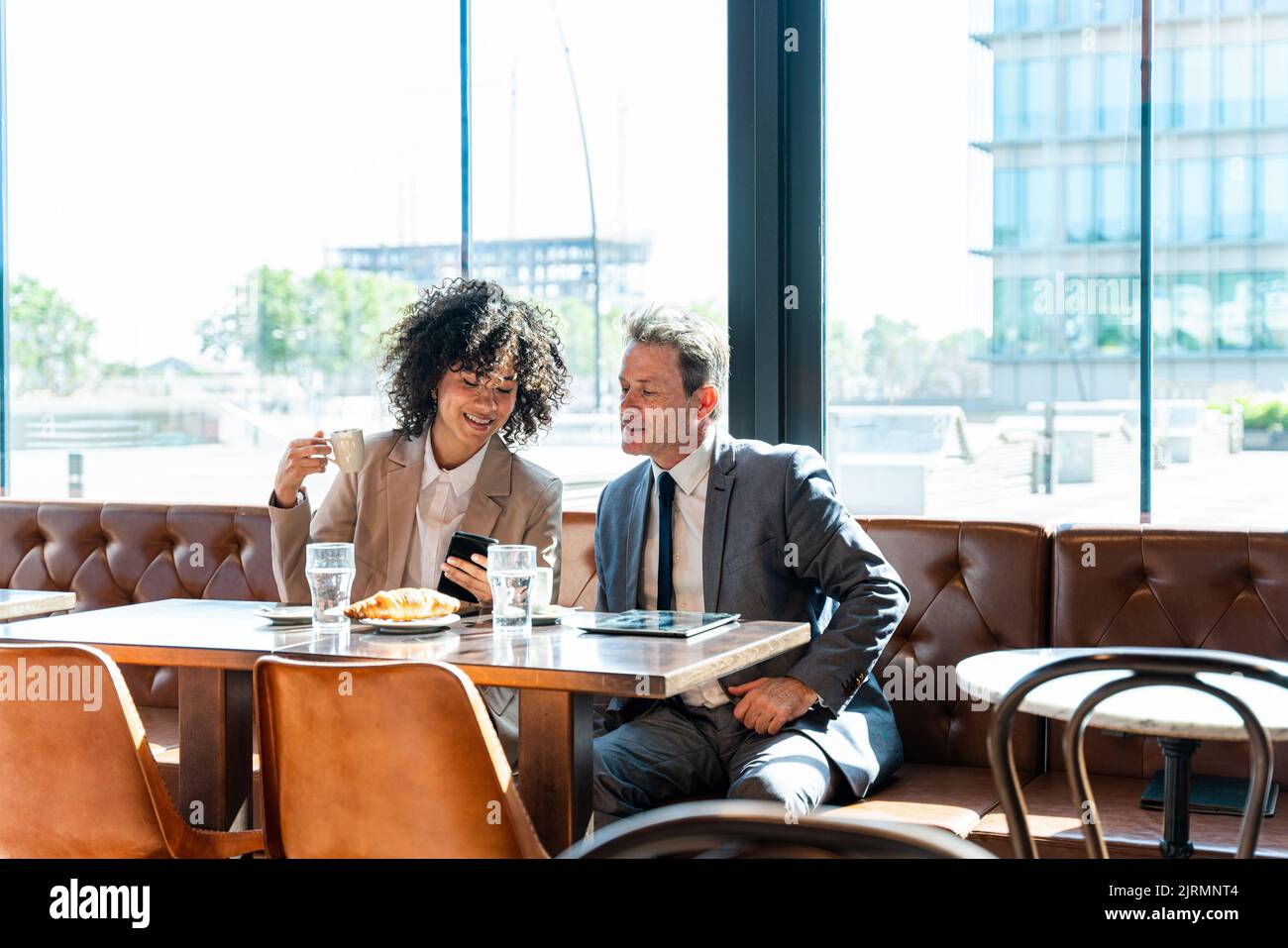 Senior businessman and beautiful hispanic businesswoman meeting in a ...