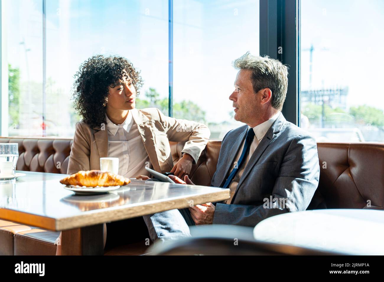 Senior businessman and beautiful hispanic businesswoman meeting in a ...
