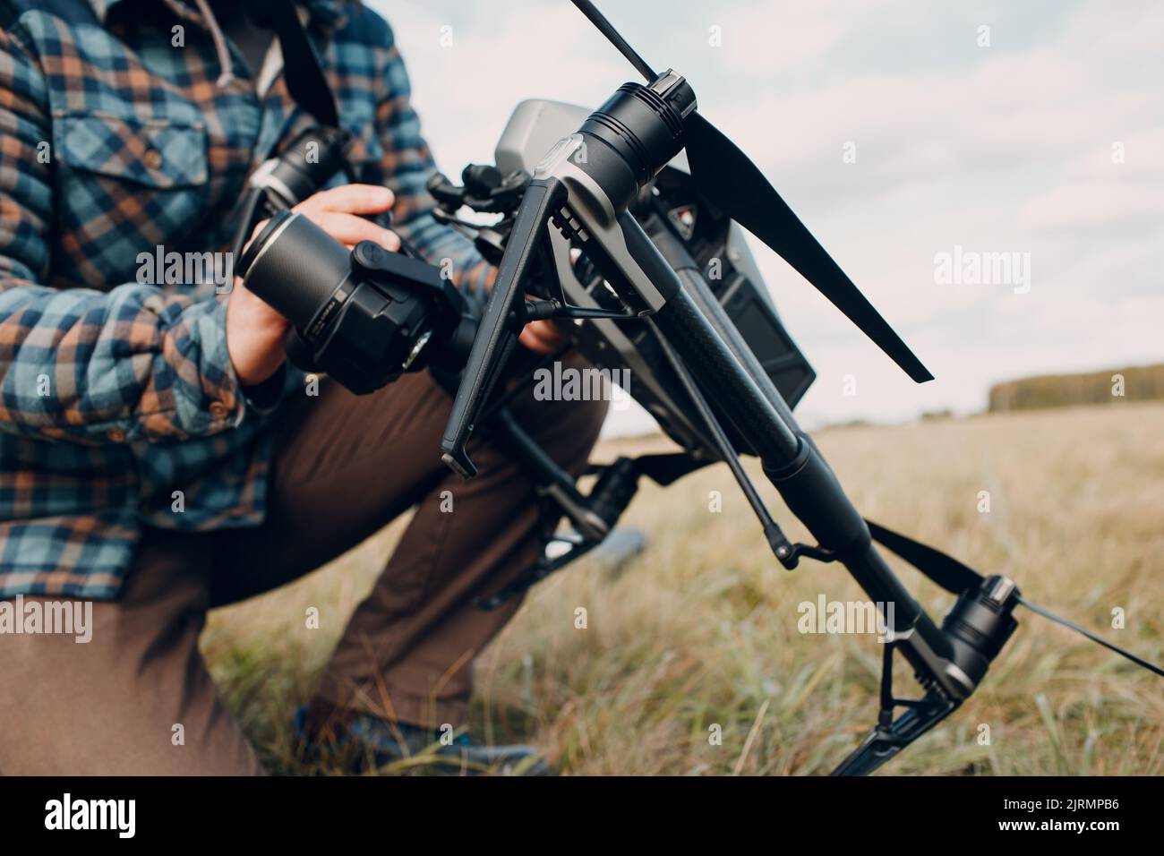 Man pilot checking quadcopter drone before aerial flight and filming Stock Photo - Alamy
