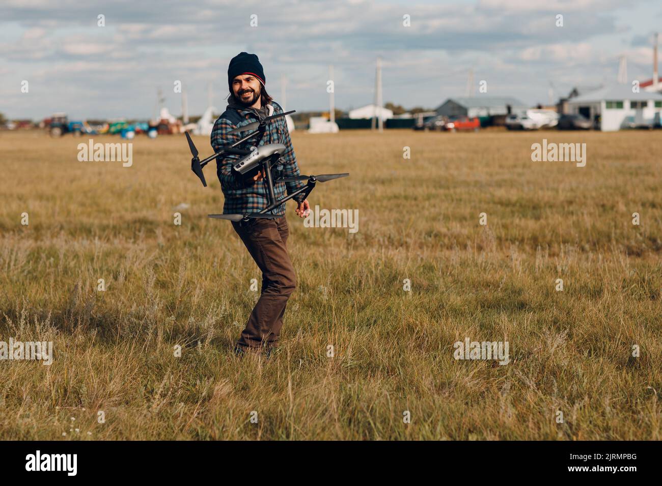 Man pilot holding quadcopter drone in hands at outside field Stock ...