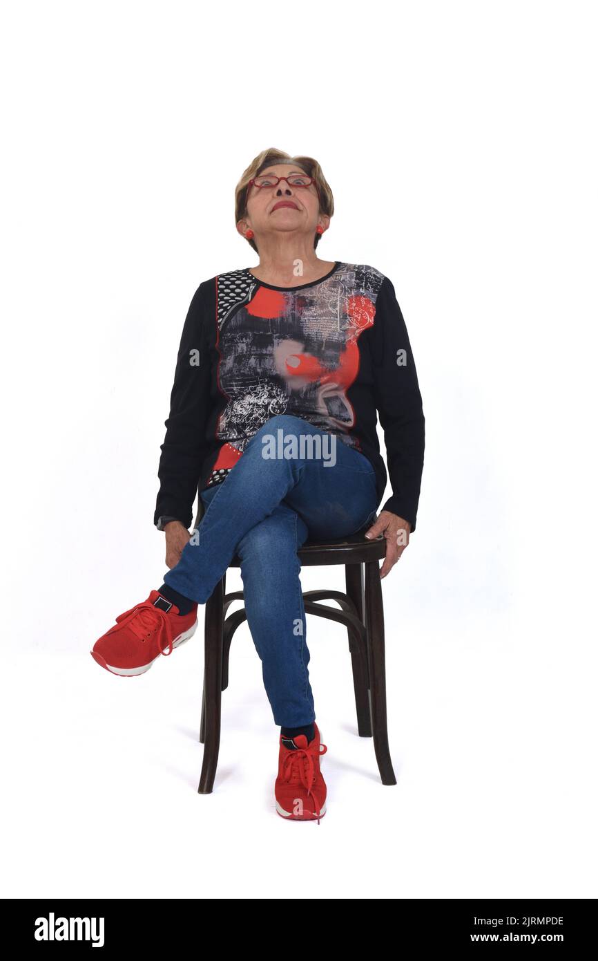 senior woman sitting o chair looking up on white background Stock Photo ...