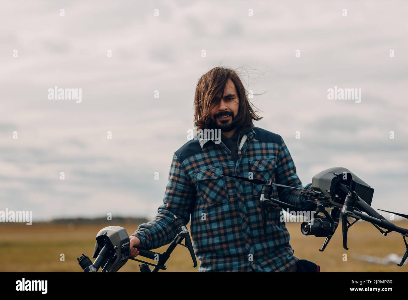 Man pilot holding quadcopter drone in hands at outside field Stock ...