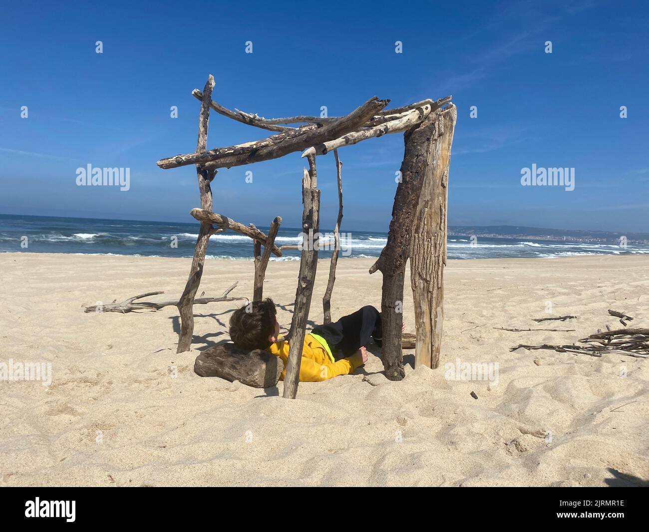 A happy kid jumping over the sand on a beach in Portugal Stock Photo ...