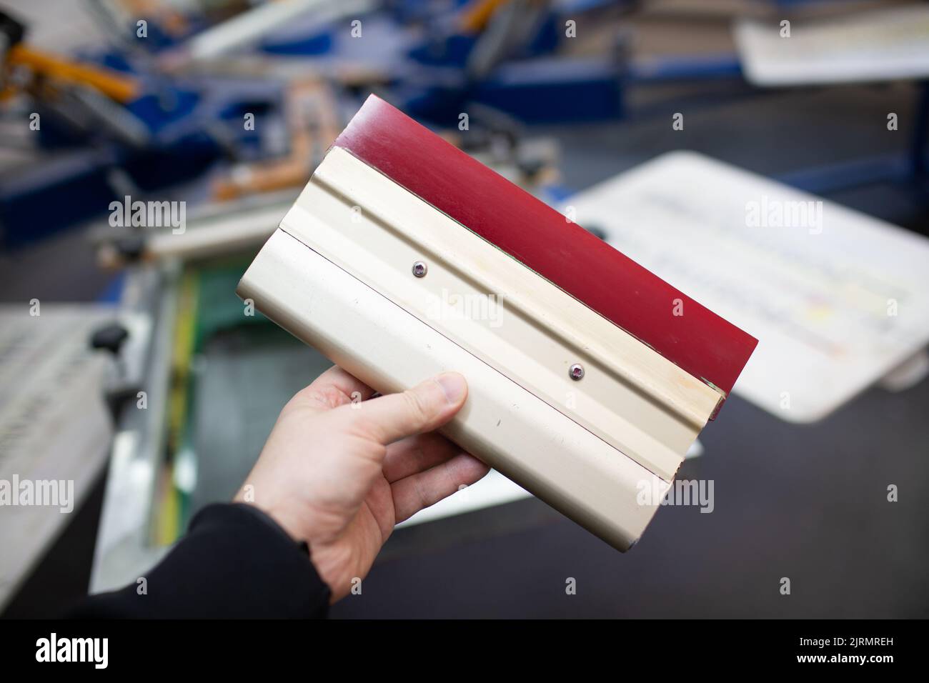 Serigraphy silk screen print process at clothes factory. Frame ...