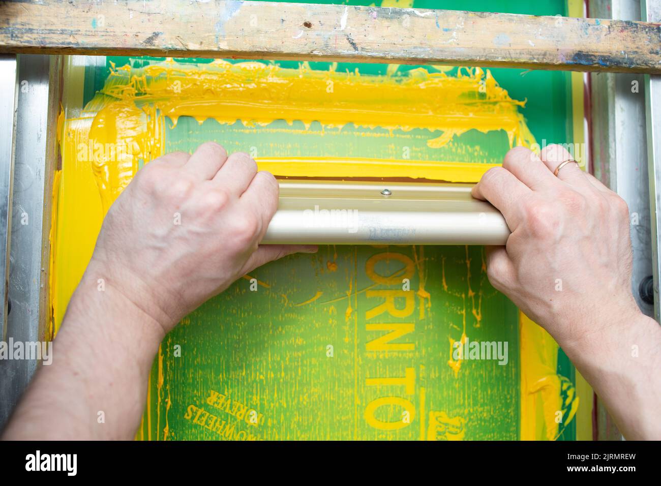 Serigraphy silk screen print process at clothes factory. Frame ...