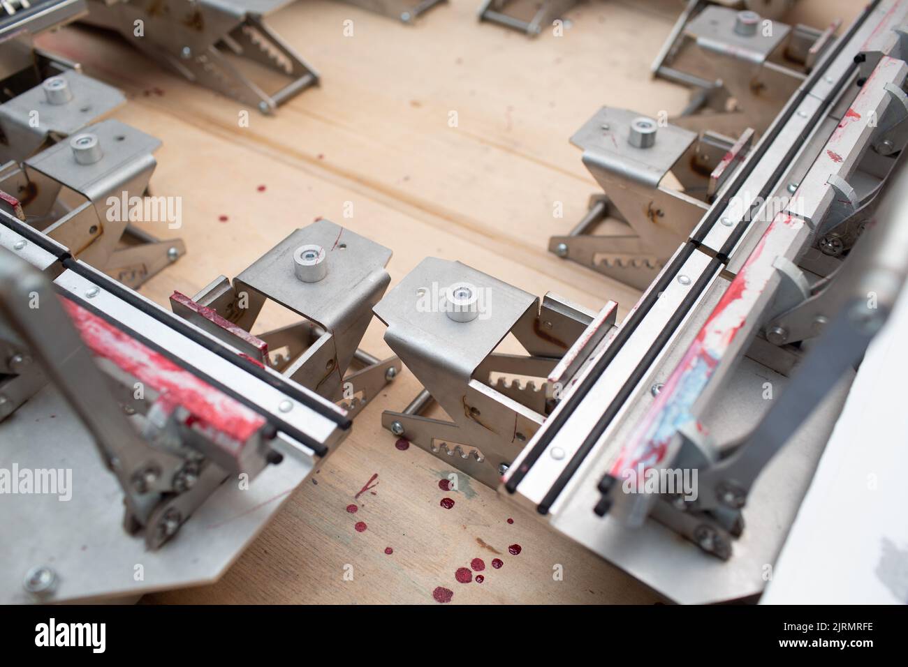 Serigraphy silk screen print process at clothes factory. Tensioner ...