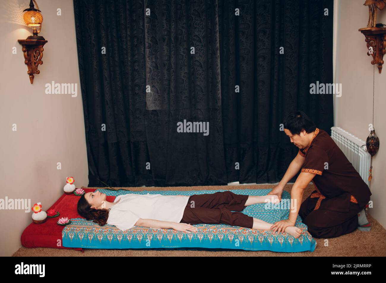 Thai man making classical thai massage procedure to young woman at ...