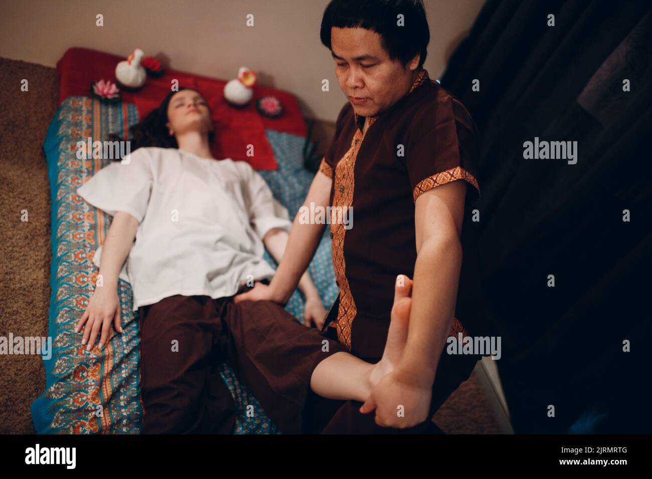 Thai man making classical thai massage procedure to young woman at ...