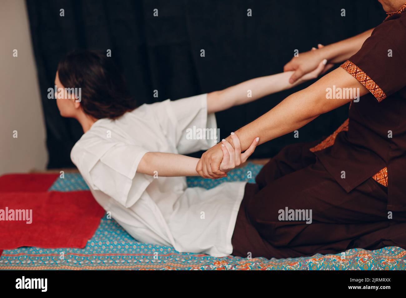 Thai man making classical thai massage procedure to young woman at ...
