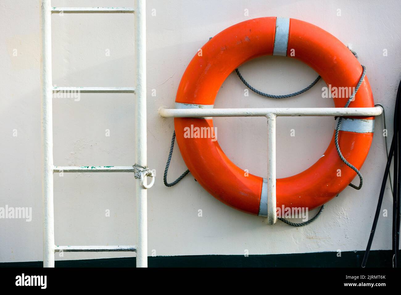 Orange Life Ring Next To A Ladder On A Ship Stock Photo - Alamy