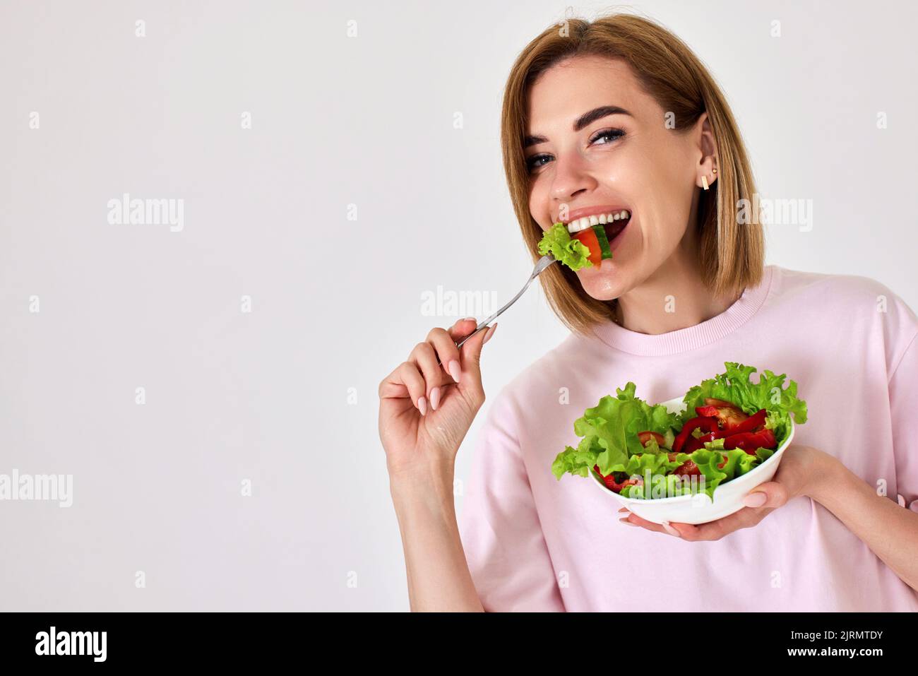 beautiful woman eating fresh vegetable salad on white background Stock ...