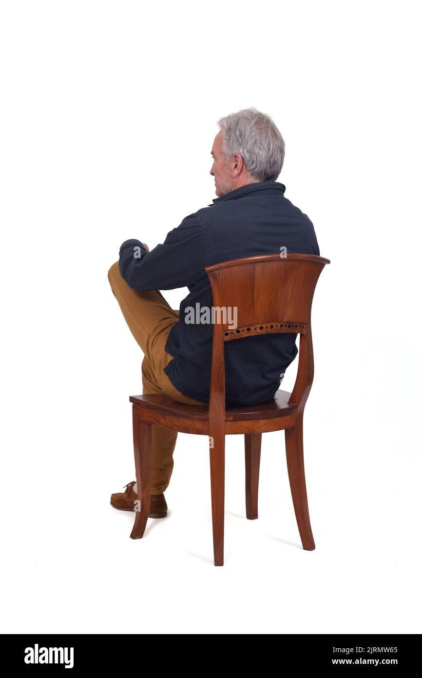 rear and side view of a man sitting on chair legs crossed on white ...
