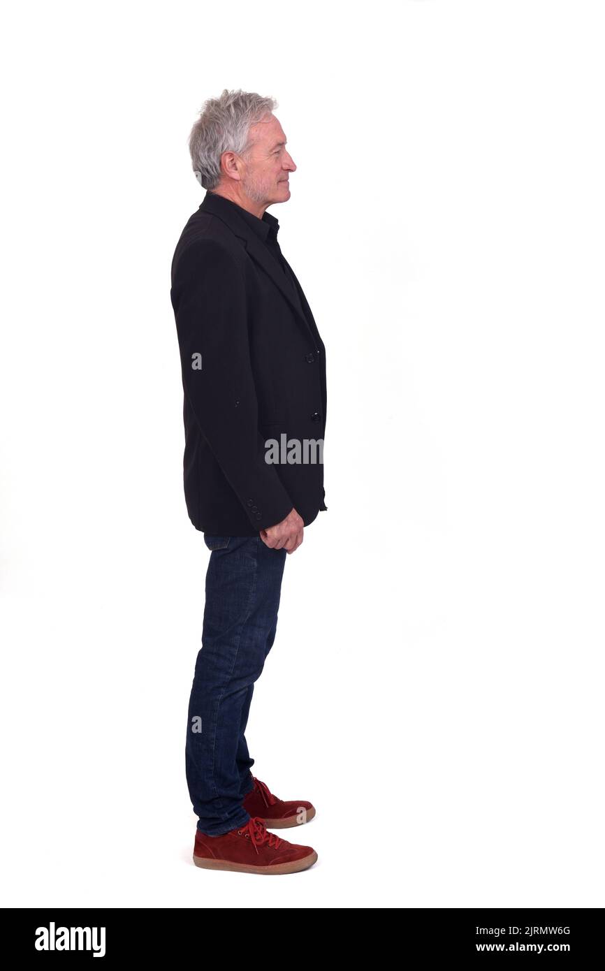 side view of man dressed in jeans sneakers and blazer on white ...