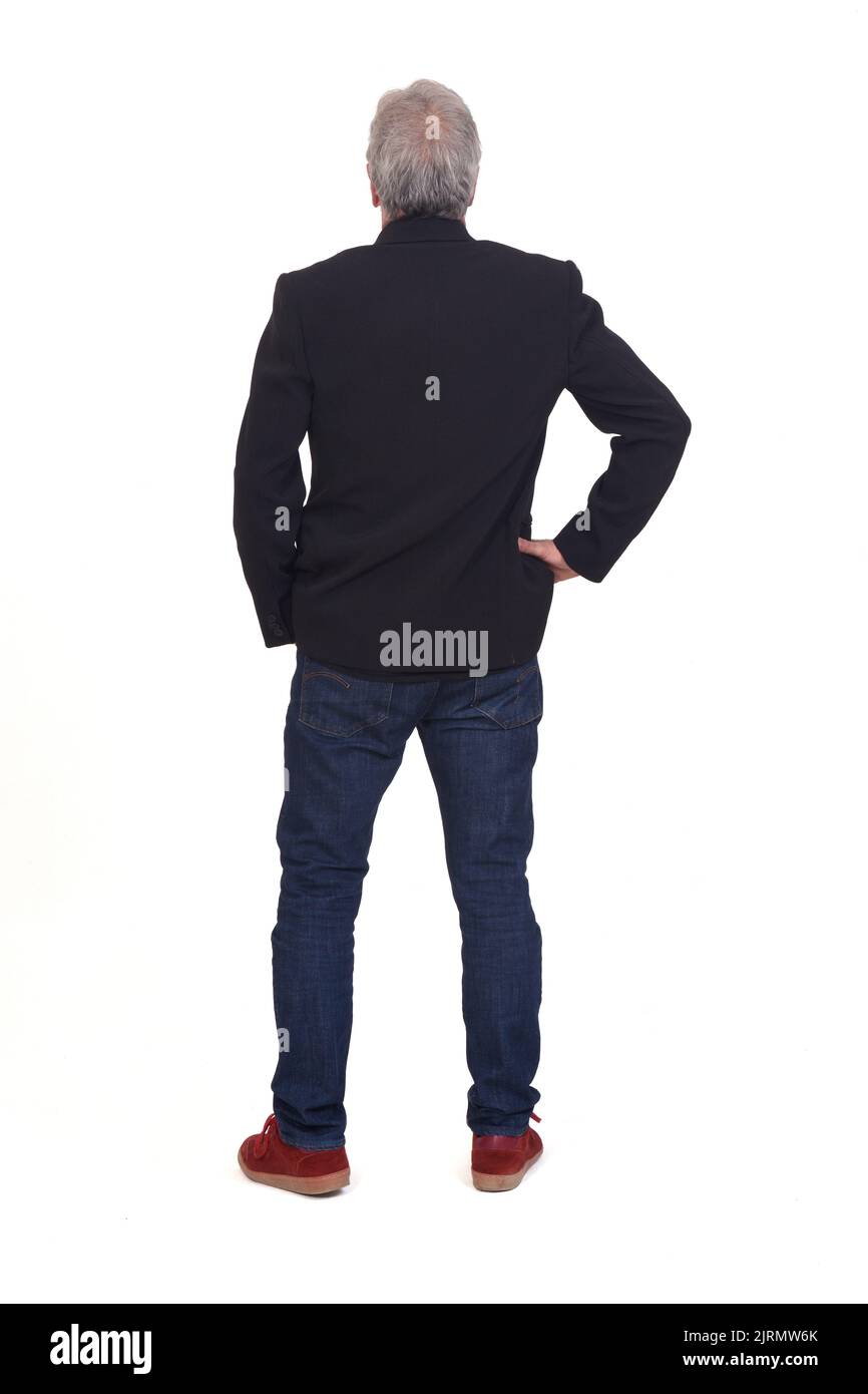 rear view of man dressed in jeans sneakers and blazer with hand on hip ...