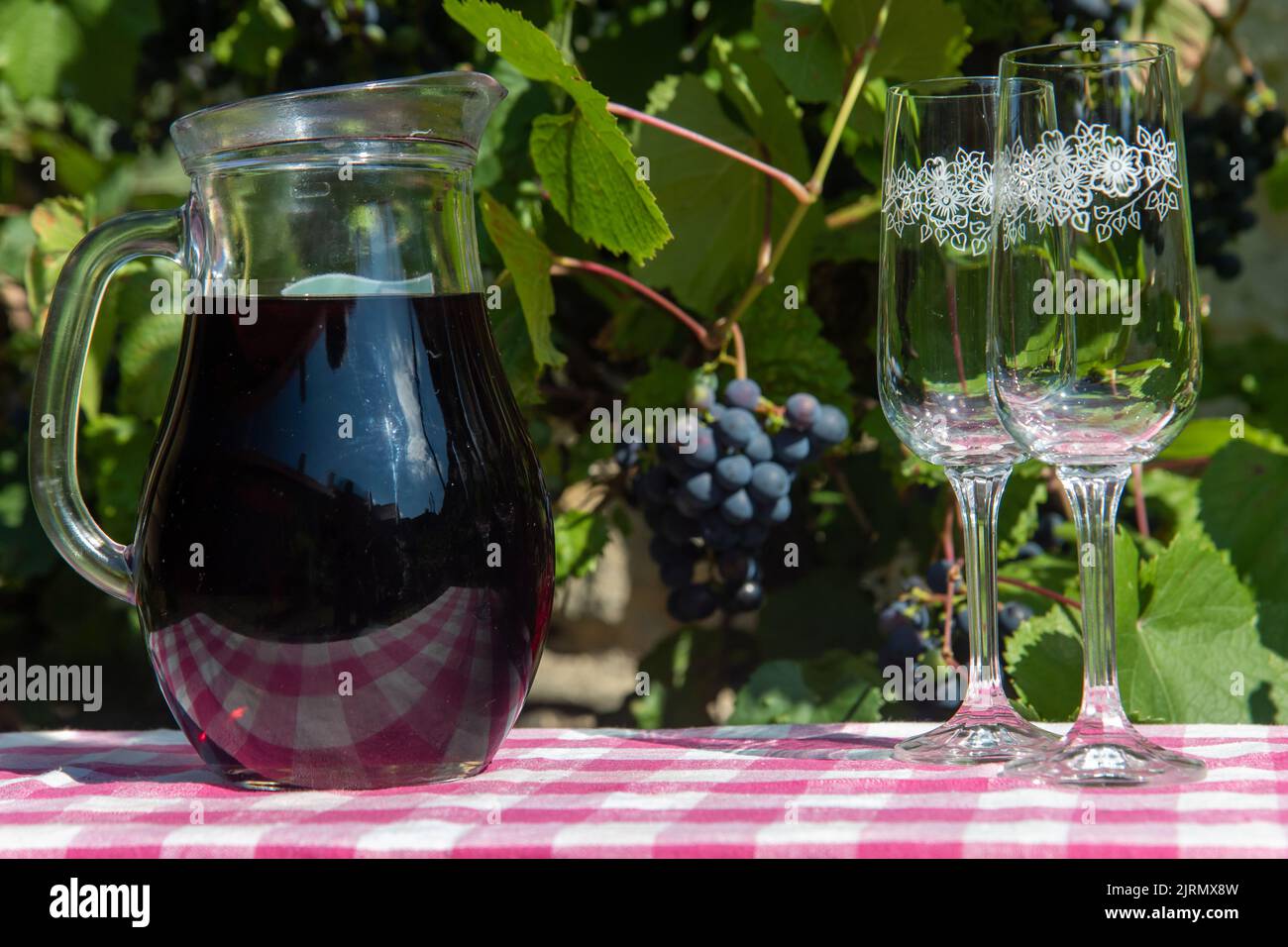 Glass jug with red wine and pair of empty wine glass on the table Stock ...