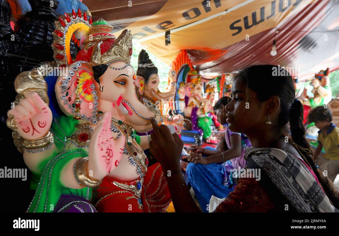 Artists work on an idol of the elephant-headed Hindu deity Ganesha ...