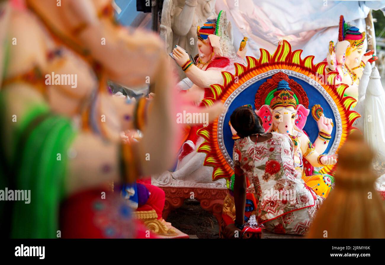 An artist works on an idol of the elephant-headed Hindu deity Ganesha ...