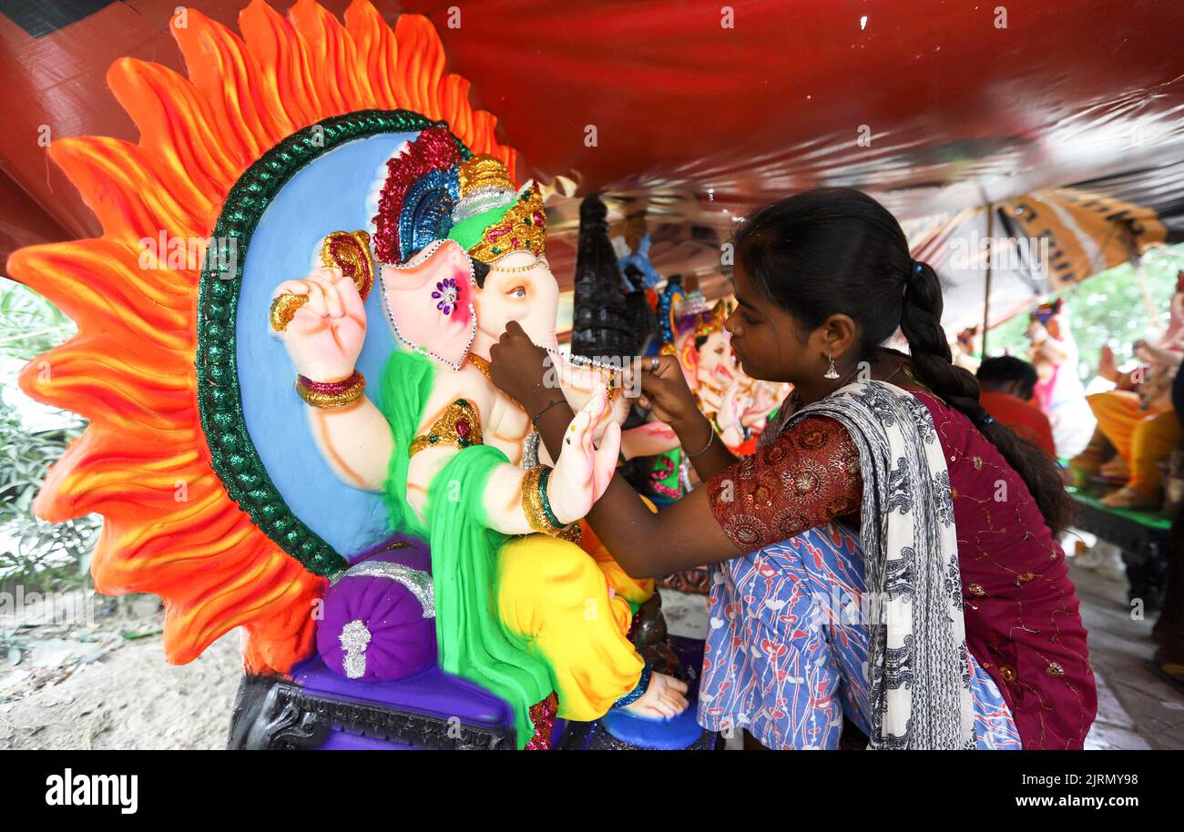 An artist works on an idol of the elephant-headed Hindu deity Ganesha ...