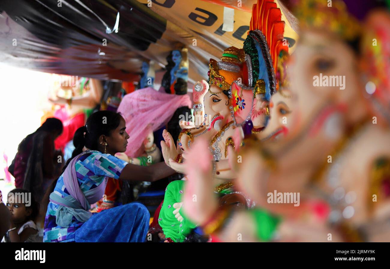 Artists work on an idol of the elephant-headed Hindu deity Ganesha ...