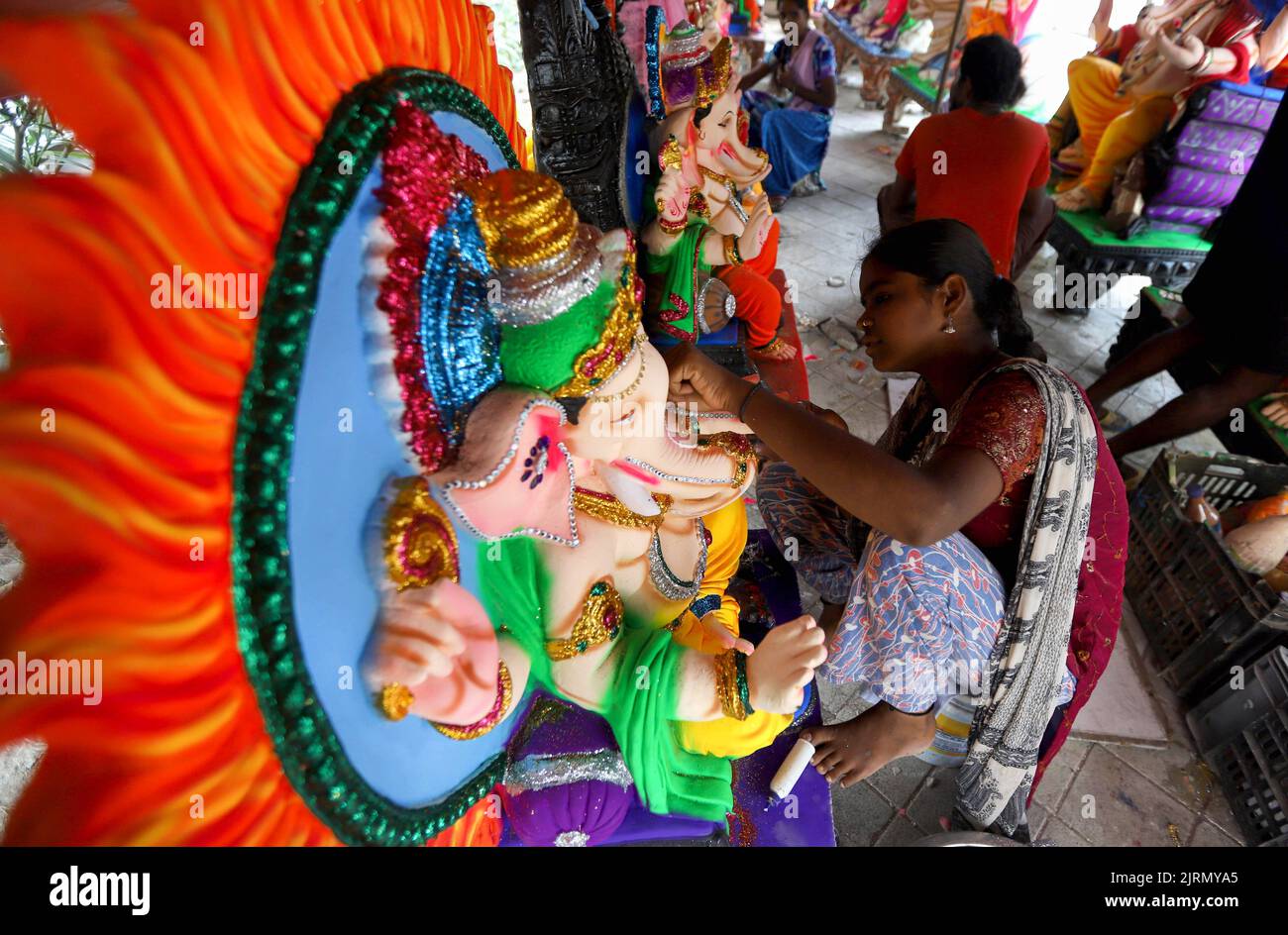 Artists work on an idol of the elephant-headed Hindu deity Ganesha ...