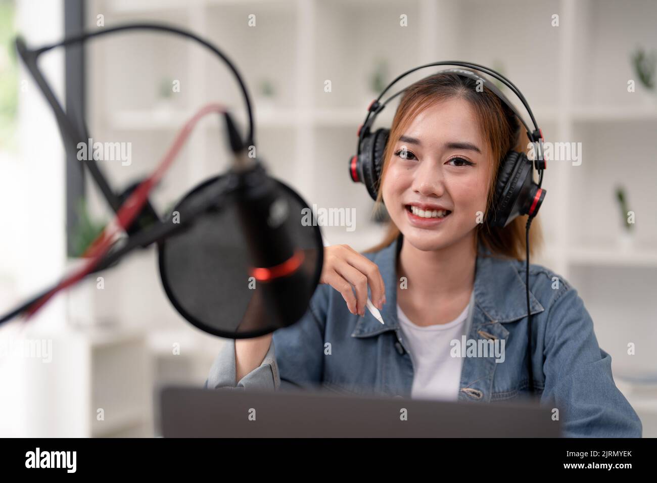 Young asian woman makes a podcast audio recording at home Stock Photo ...