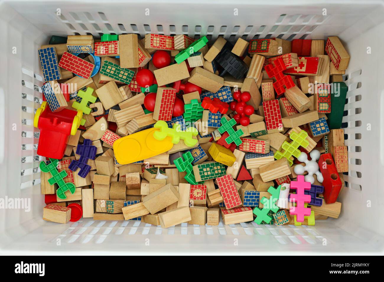 White plastic box with several toys in different colors and in ...