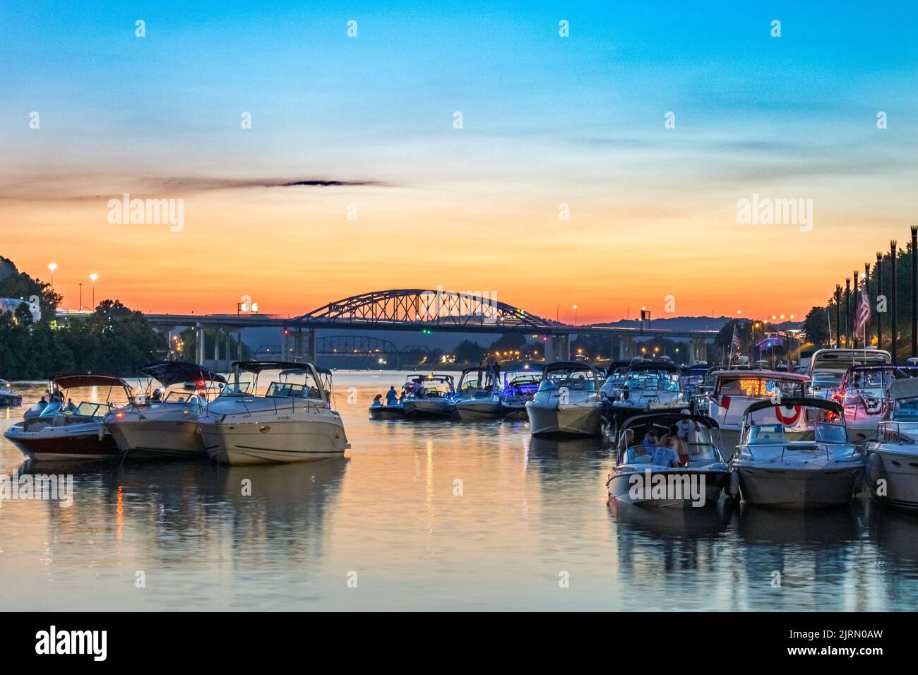 Several boats floating in a river on a summer evening during the sunset ...