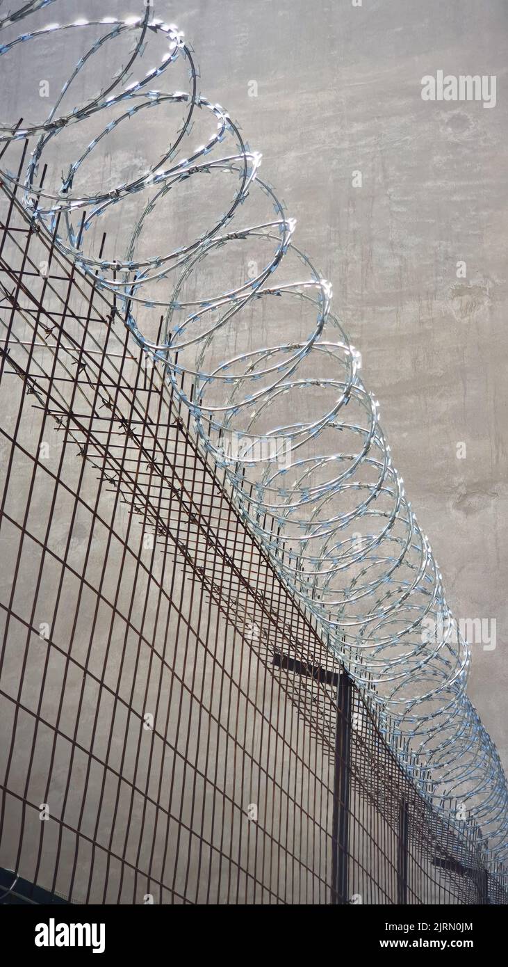 Concertina barb wire, heavy duty, metal fence. A prison, crime concept ...