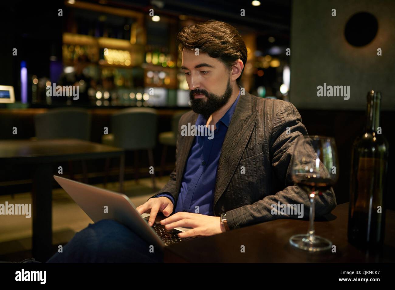 Entrepreneur working on laptop and drinking good wine in restaurant ...