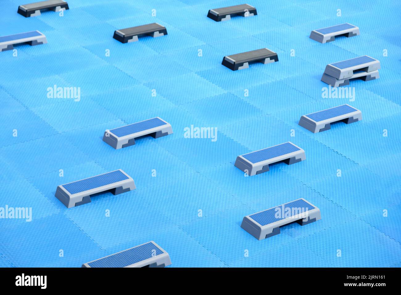 Step boards on soft blue mat in aerobics class Stock Photo - Alamy