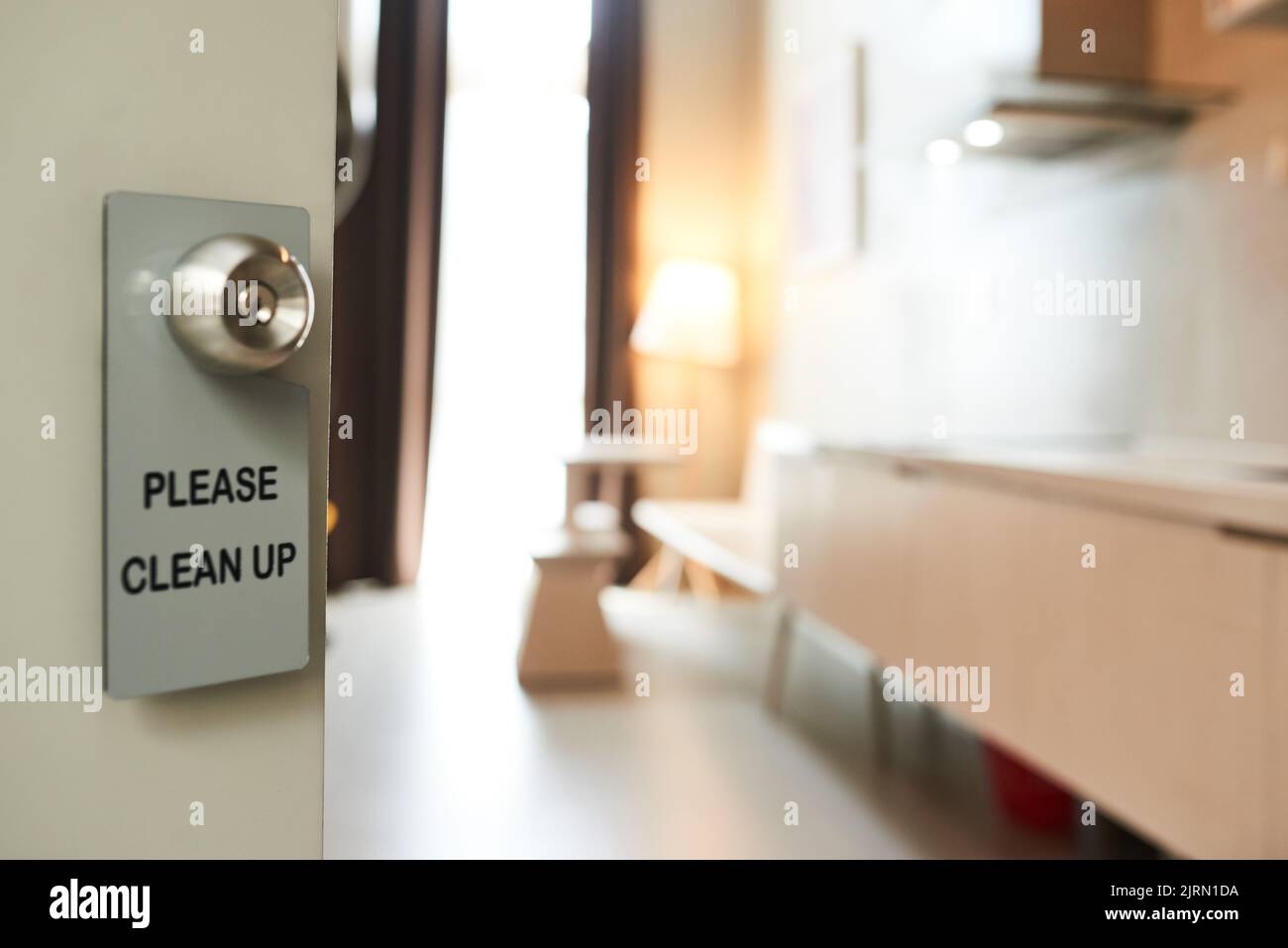 Opened door of hotel room with please clean up sign Stock Photo - Alamy