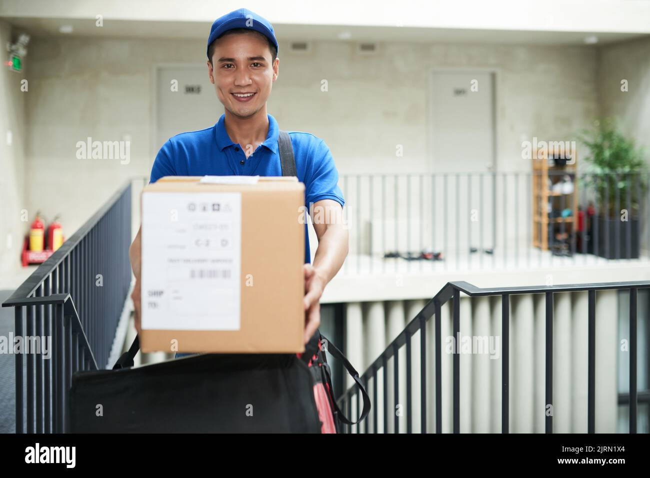 Happy postman giving you a big bag Stock Photo - Alamy