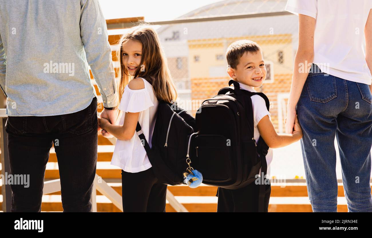 Two children hand in hand with their parents, with mother and father ...