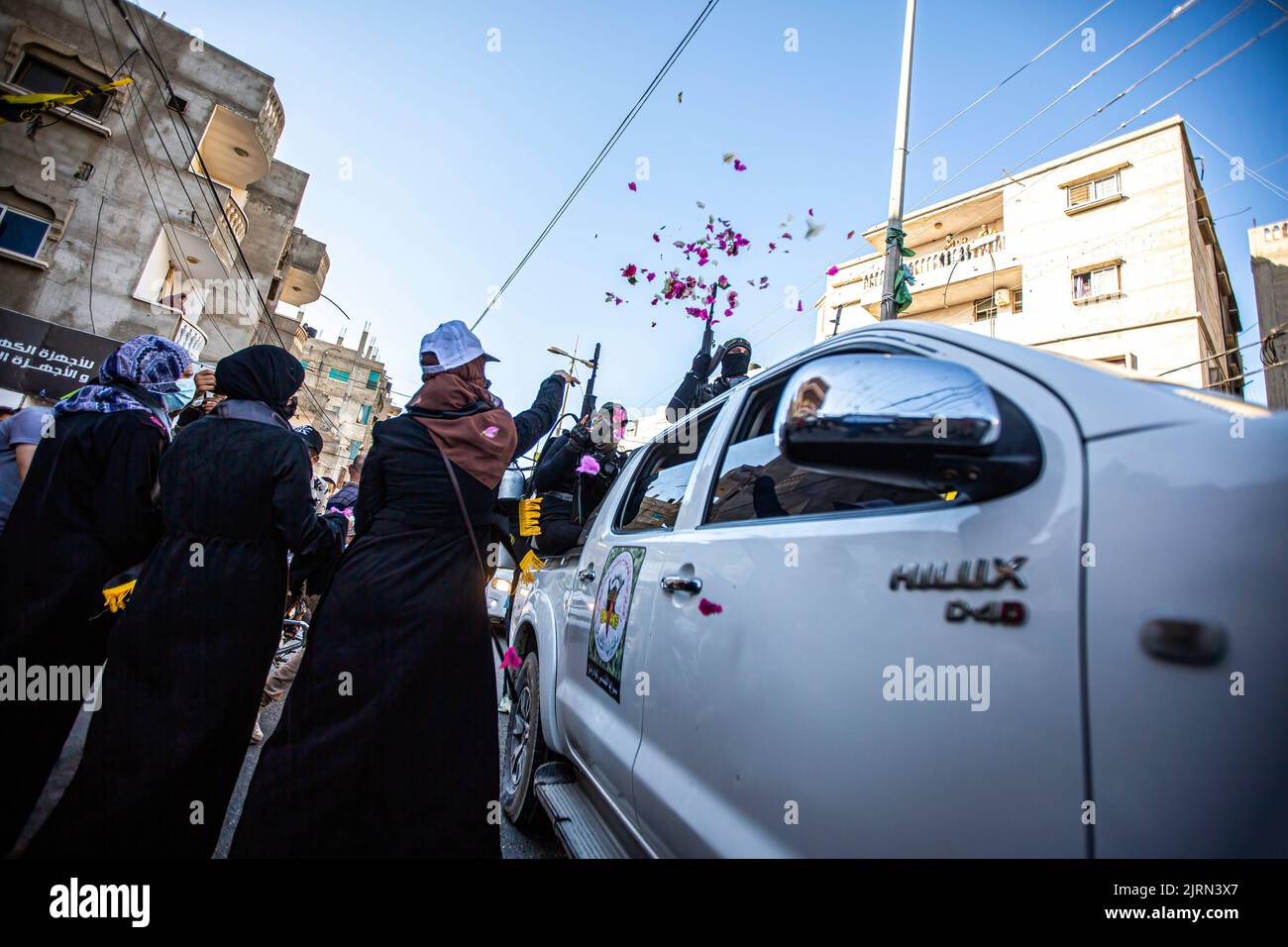 Women sprinkle roses on fighters of Saraya al-Quds, the military wing ...