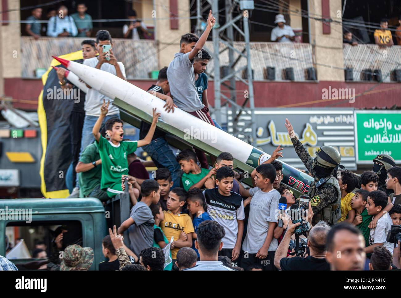 Palestinian children aboard a truck carrying missiles made by Al-Quds ...