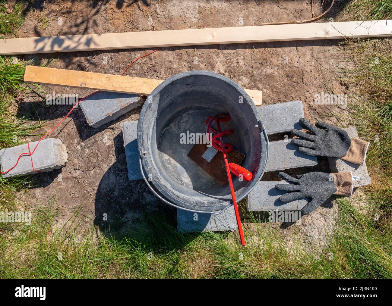 A top view of tools in a bucket and gloves on stones Stock Photo - Alamy