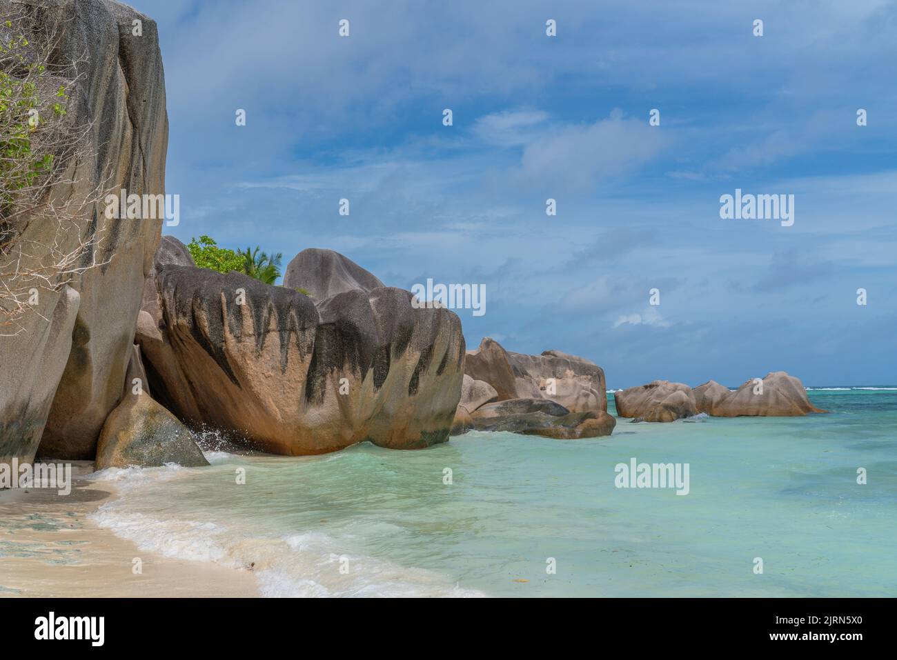 An aerial view of sea with beach surrounded by big rock formations ...