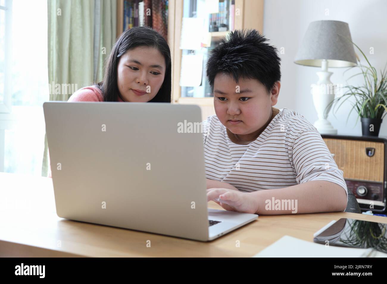 The Asian single mom helping her son to learn from home Stock Photo - Alamy