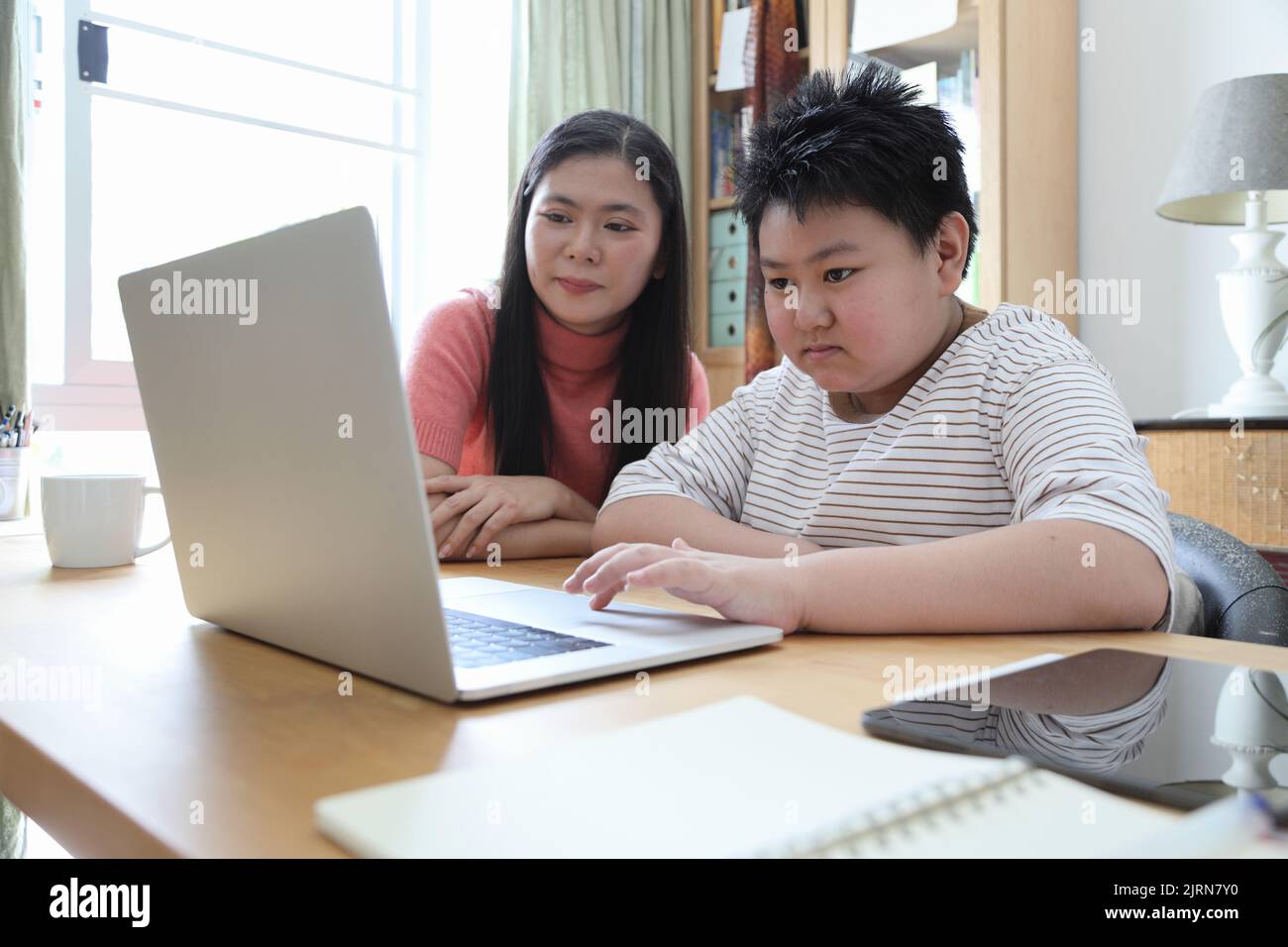 The Asian single mom helping her son to learn from home Stock Photo - Alamy