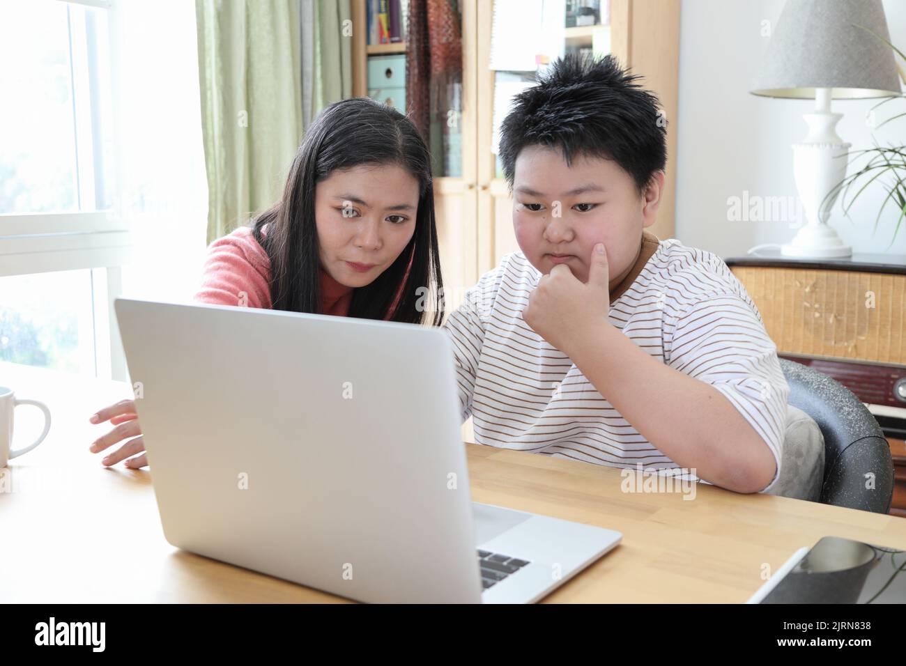 The Asian single mom helping her son to learn from home Stock Photo - Alamy