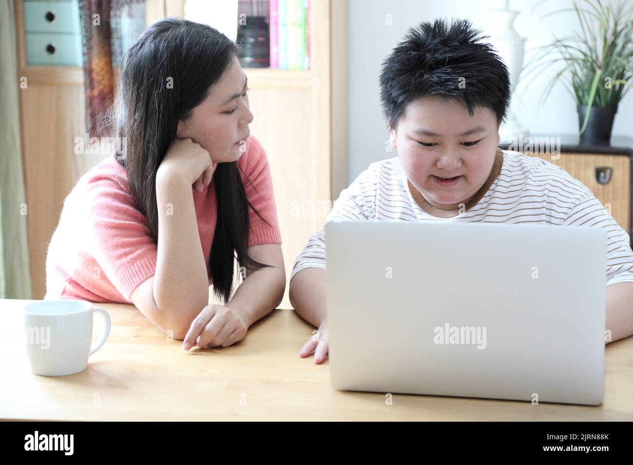 The Asian single mom helping her son to learn from home Stock Photo - Alamy